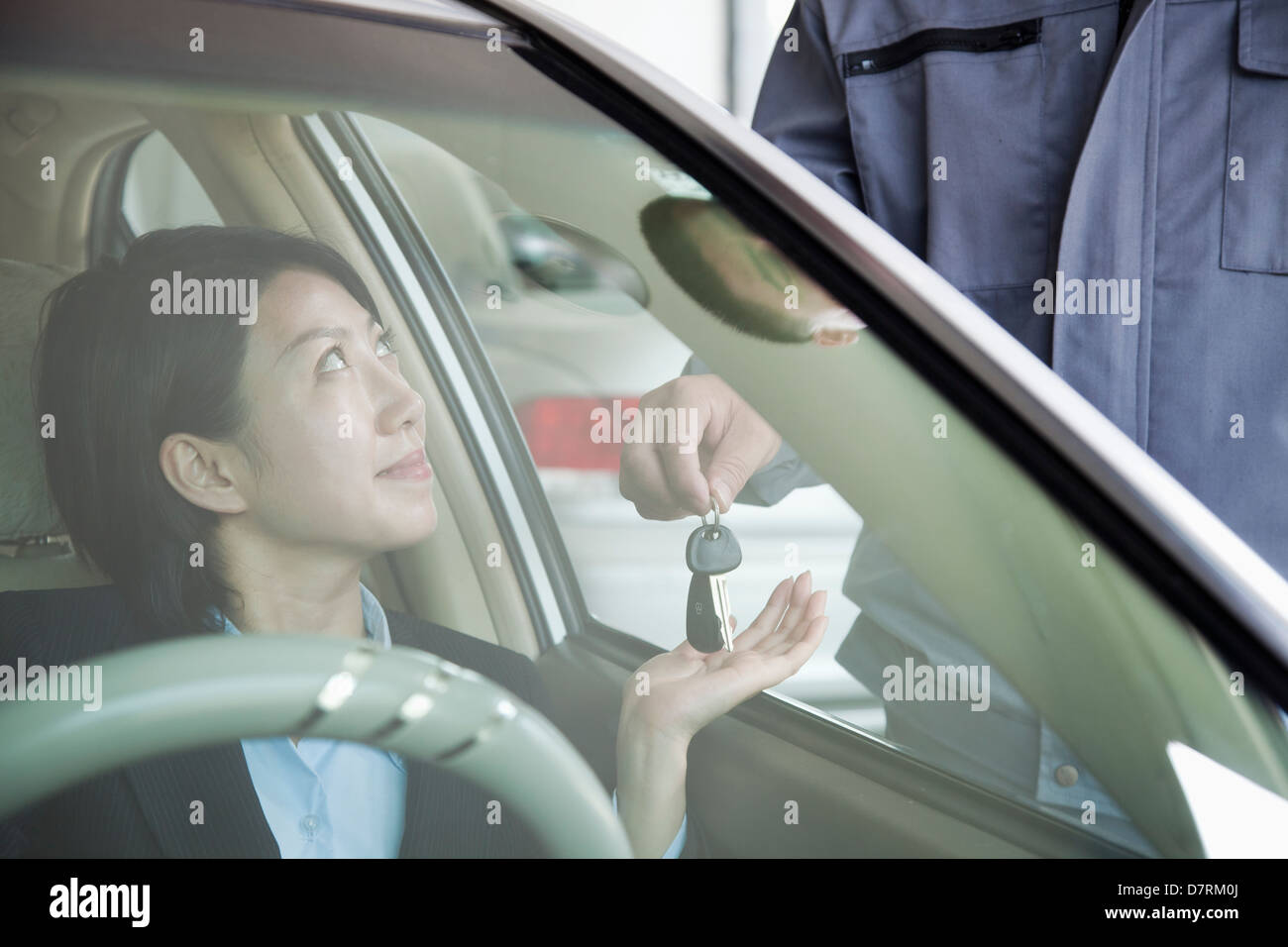 Mechanic Handing Keys to Businesswoman Stock Photo - Alamy
