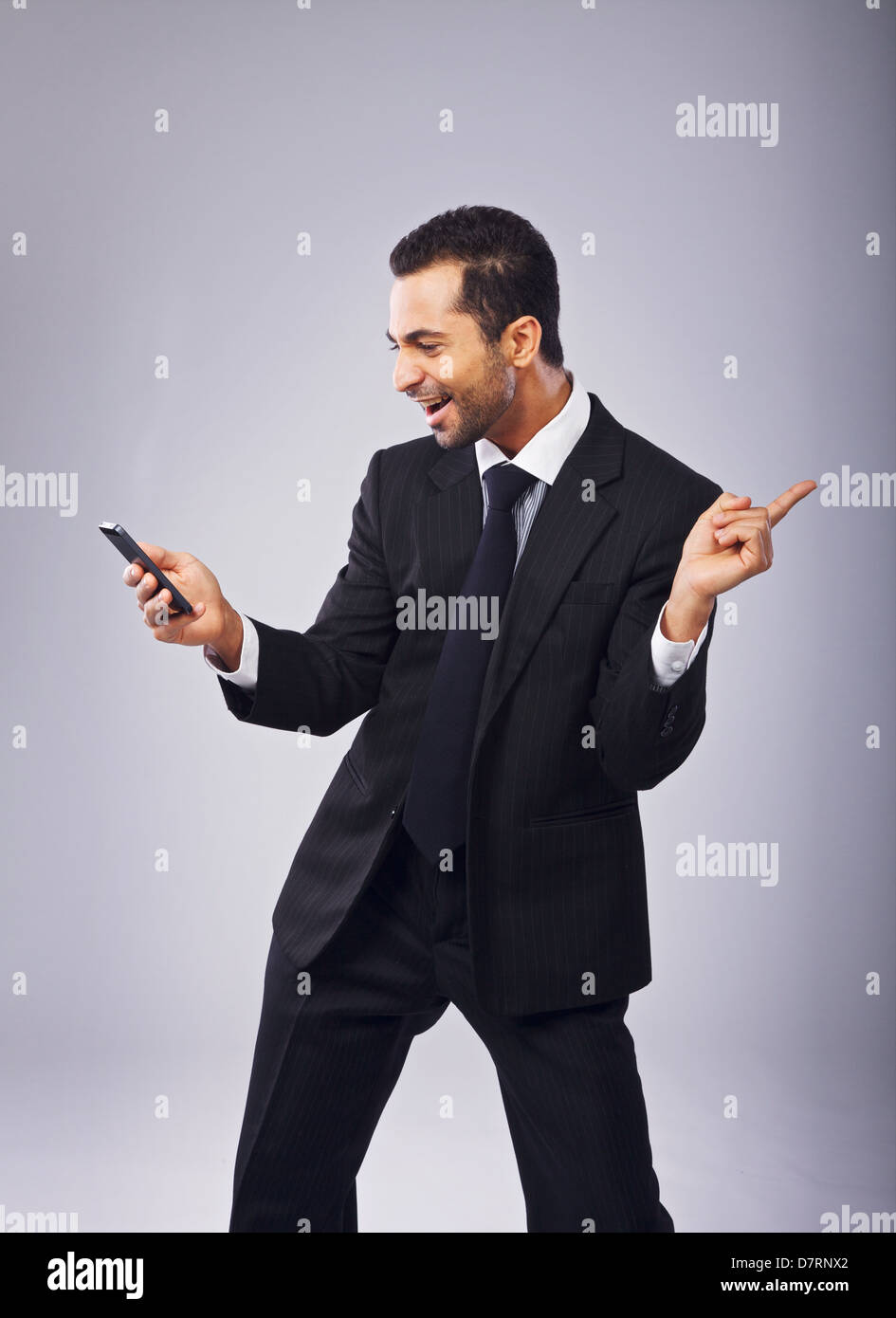 Young businessman with phone dancing out of joy Stock Photo - Alamy