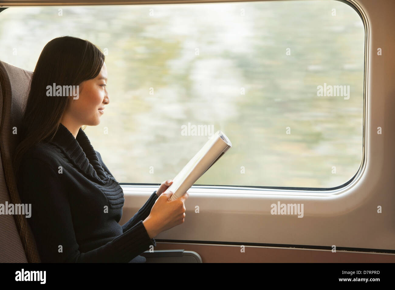 Young Woman Reading a Magazine While Riding the Train Stock Photo - Alamy