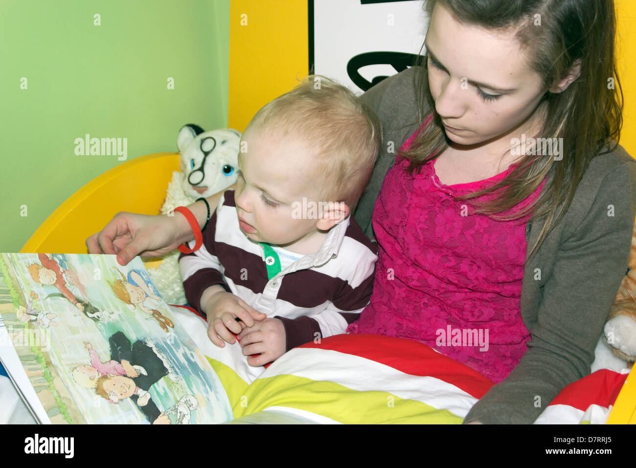 Young girl reading a story to a little boy Stock Photo - Alamy