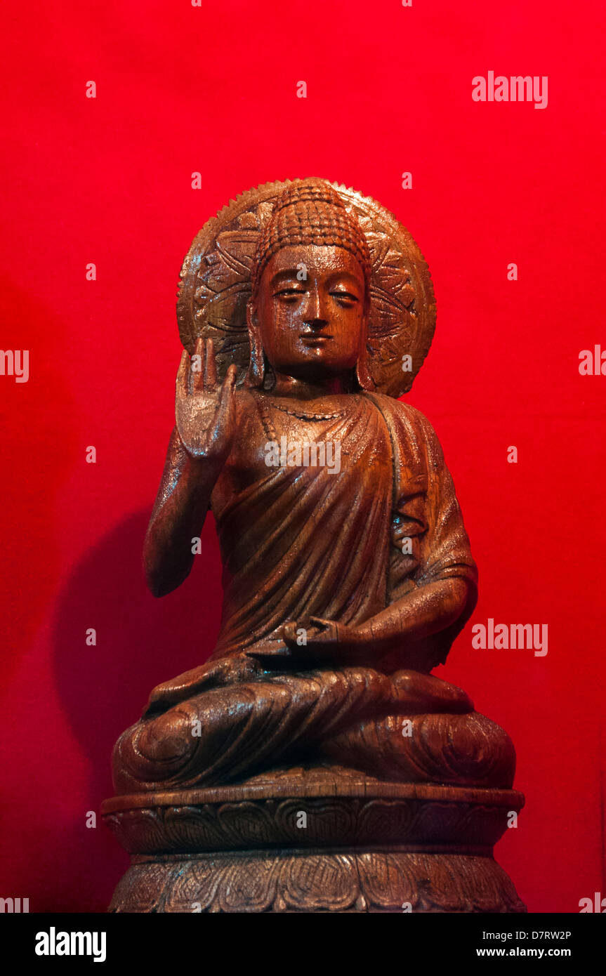 Buddha wooden statue in red background Stock Photo - Alamy