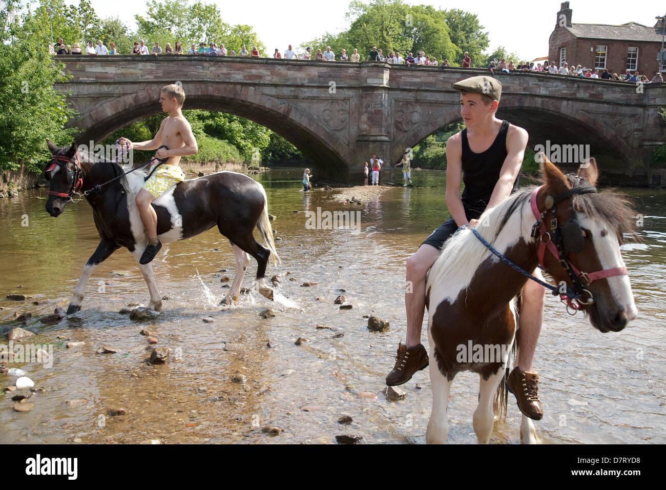 Boys riding horses in the river Eden during the Appleby Fair, an annual ...