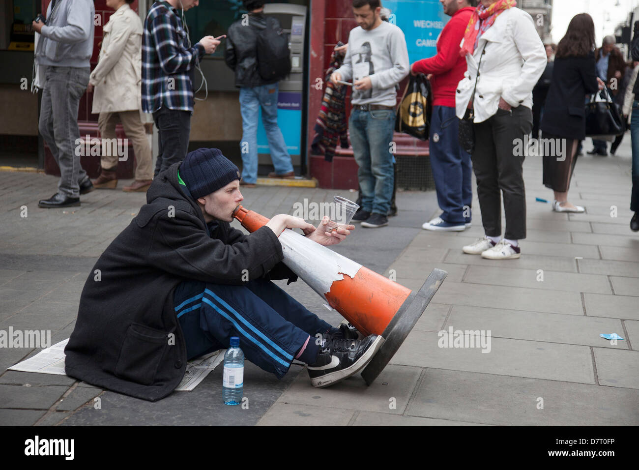 Homeless man busking to make a little money by making music with his ...