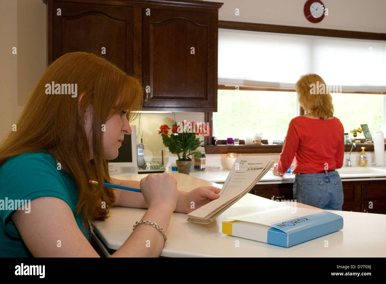 student doing homework in kitchen with parent Stock Photo - Alamy