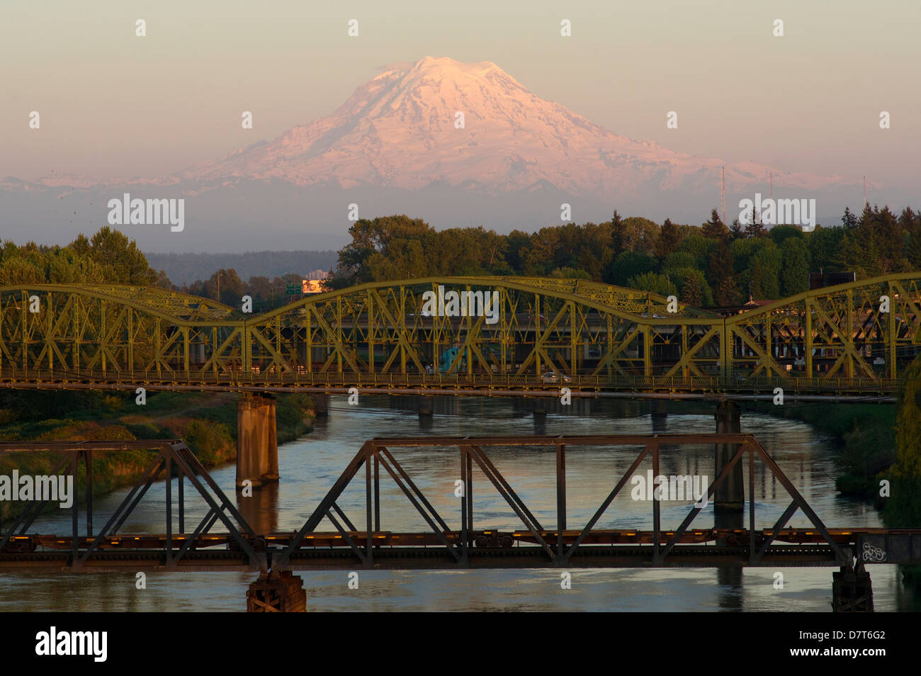 The Puyallup River meanders down from the glaciers on Mount Rainier under bridges through cities ...