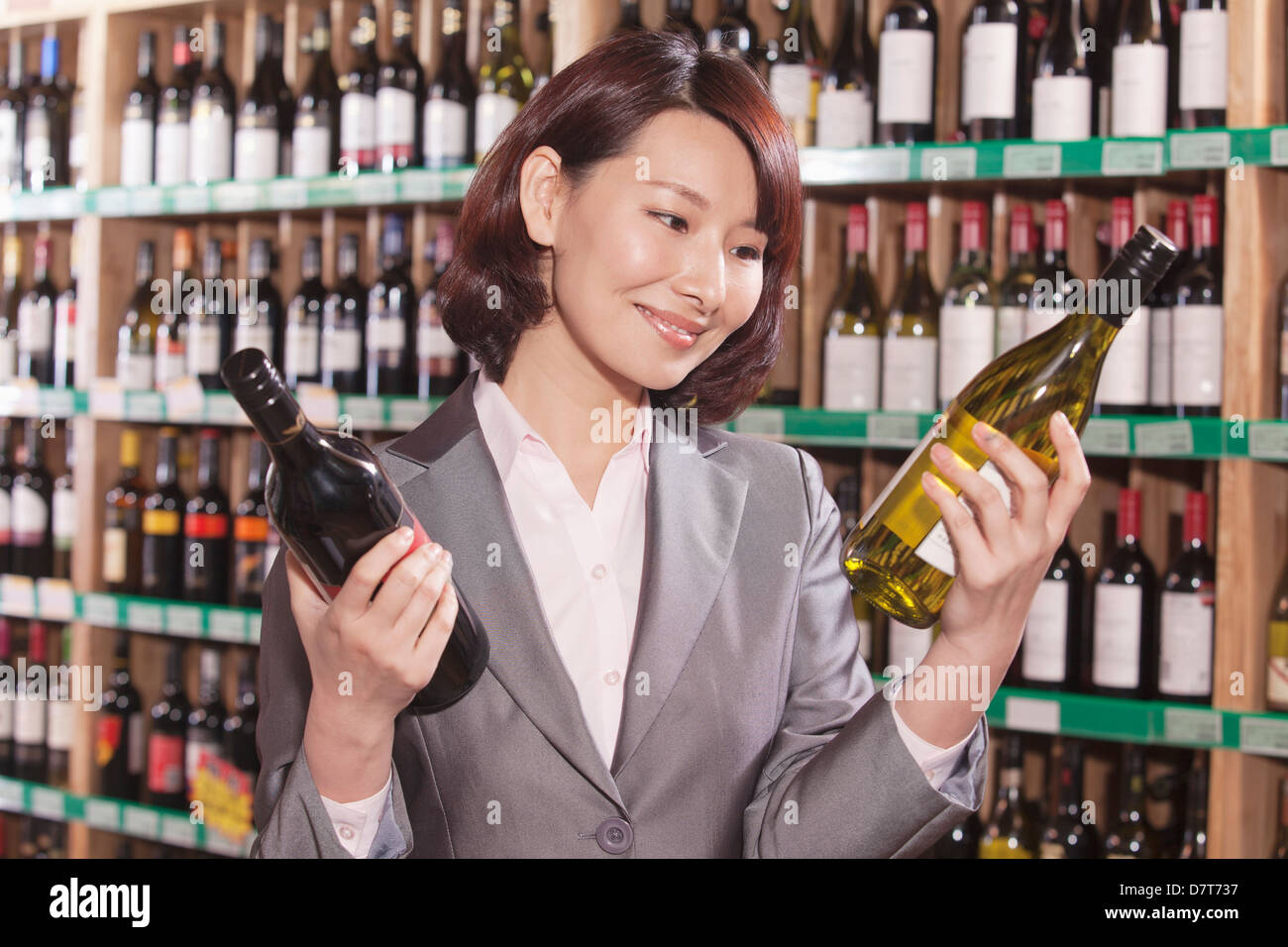 Mid Adult Woman Choosing Wine in a Liquor Store Stock Photo - Alamy