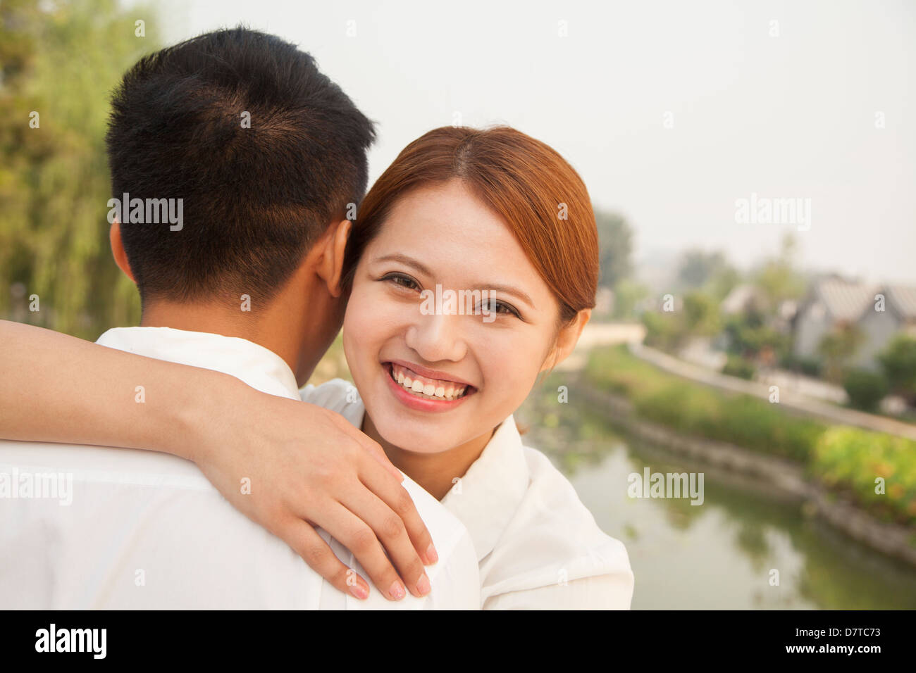 Young Woman Hugging Her Boyfriend Stock Photo - Alamy