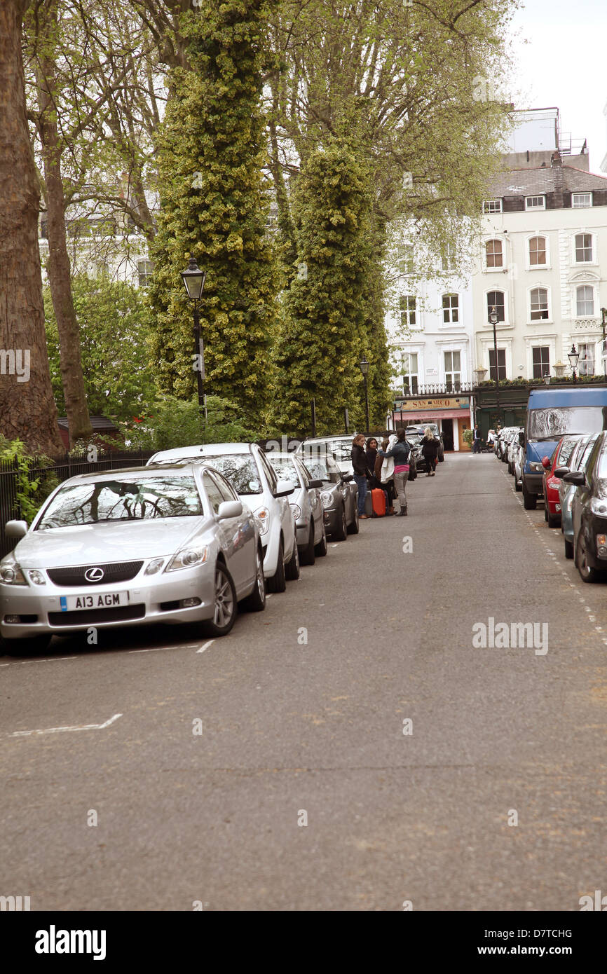 A London side street full of parked cars with just one space left anf a ...