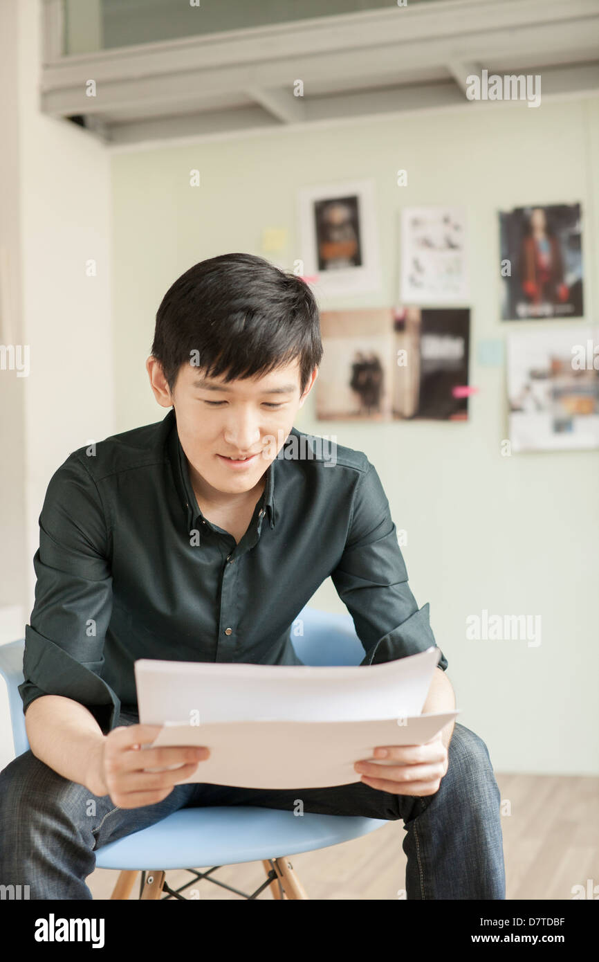 Professional Man Looking at Papers in Office Stock Photo - Alamy