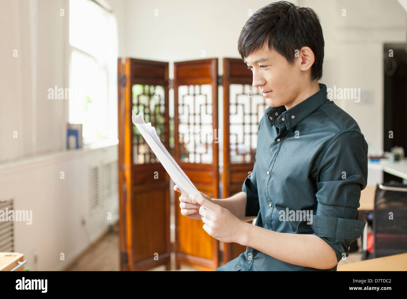 Professional Man Looking at Papers in Office Stock Photo - Alamy