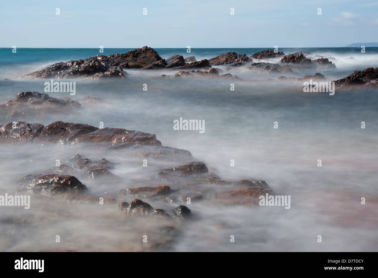 Long exposure picture of sea water passing through rocks on the beach ...