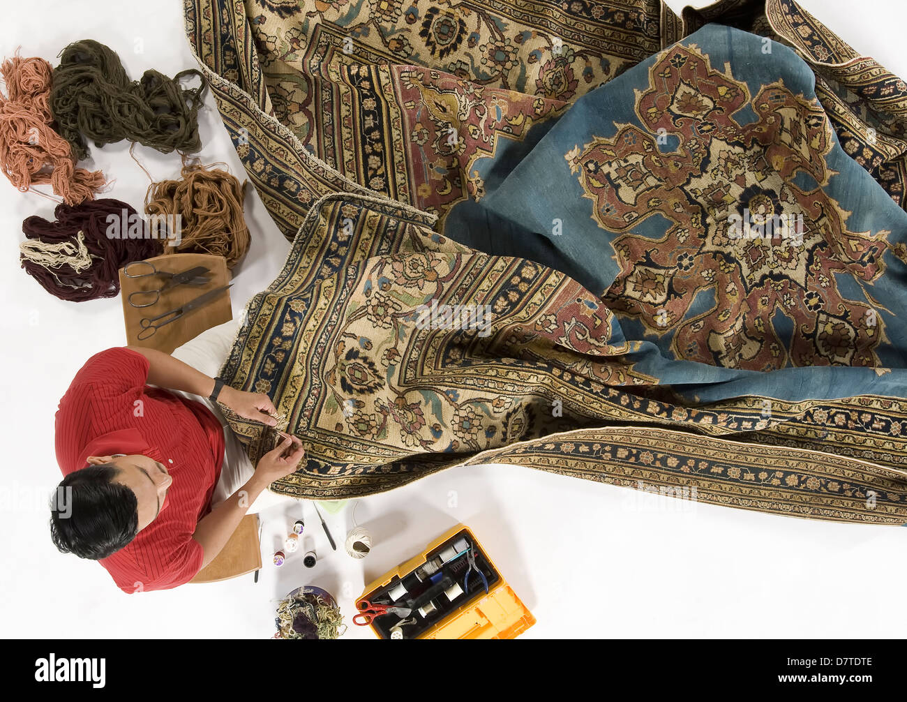 An overhead view of an Oriental rug being repaired. A studio photo on a ...