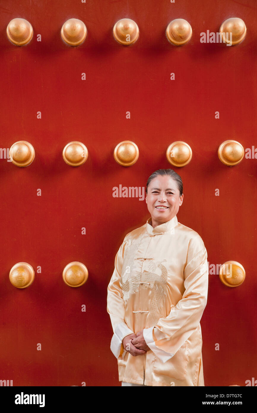 Mature woman in traditional clothes standing next to traditional ...