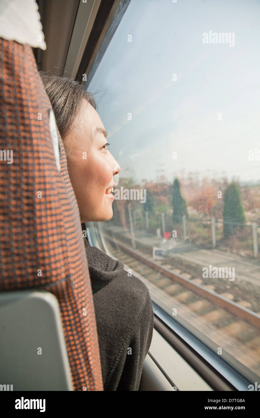 Young Woman Looking Out the Window of a Train Stock Photo - Alamy