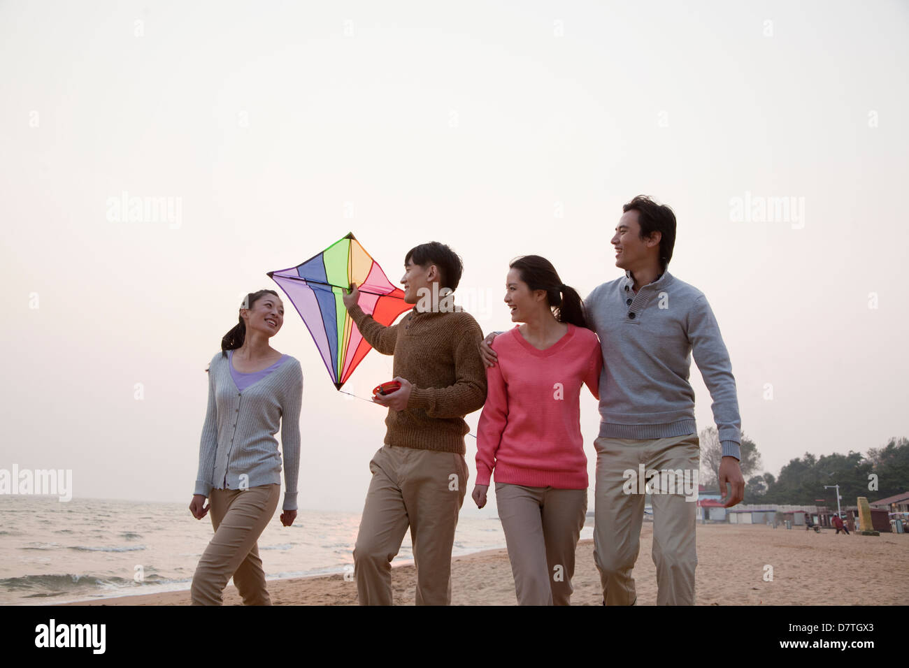 Young Friends Flying a Kite on the Beach Stock Photo - Alamy