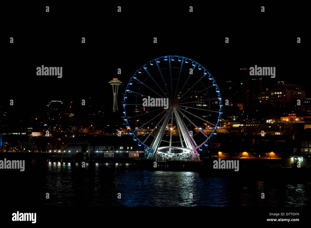 USA, WA, Seattle. Waterfront dramatic by night with lights on iconic ...