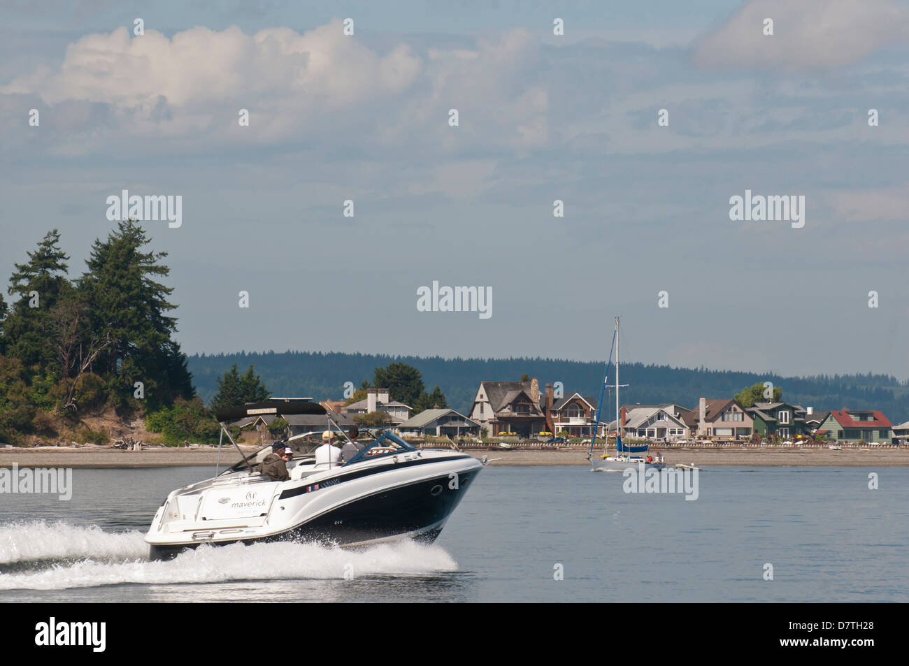 USA, WA, Whidbey Island. Motor and sailboat navigate past Sandy Point ...
