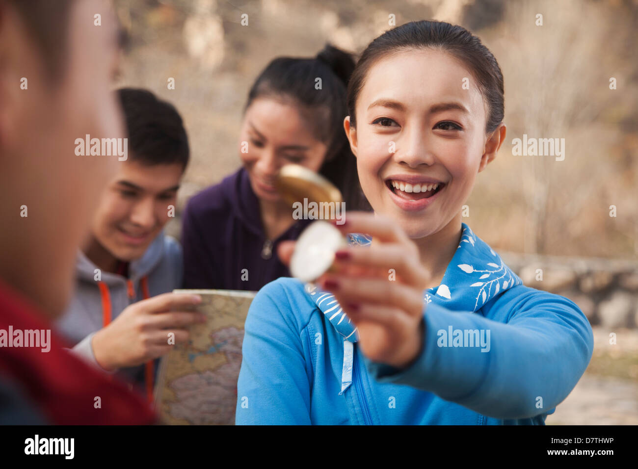 Young woman showing compass to her friend Stock Photo - Alamy