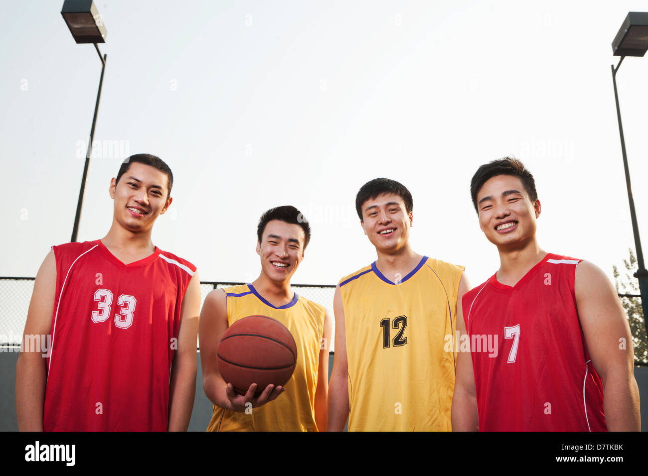 Two opposite basketball teams standing and smiling, Portrait Stock ...
