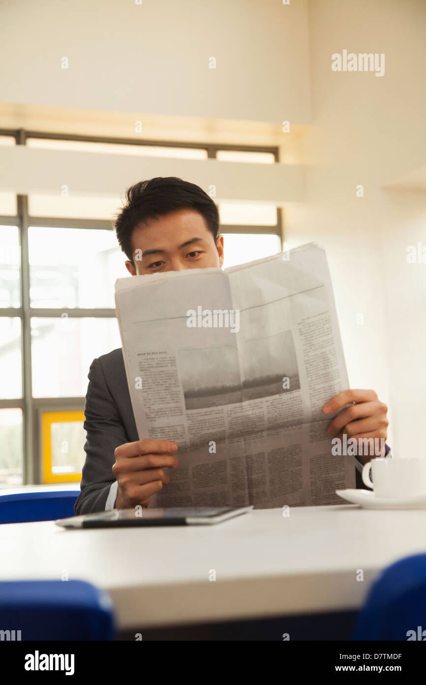 Businessman reading newspaper in company cafeteria Stock Photo - Alamy