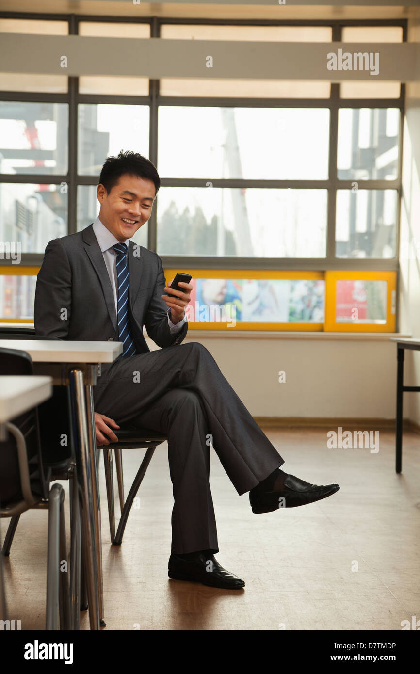 Businessman checking cell phone in company cafeteria Stock Photo - Alamy