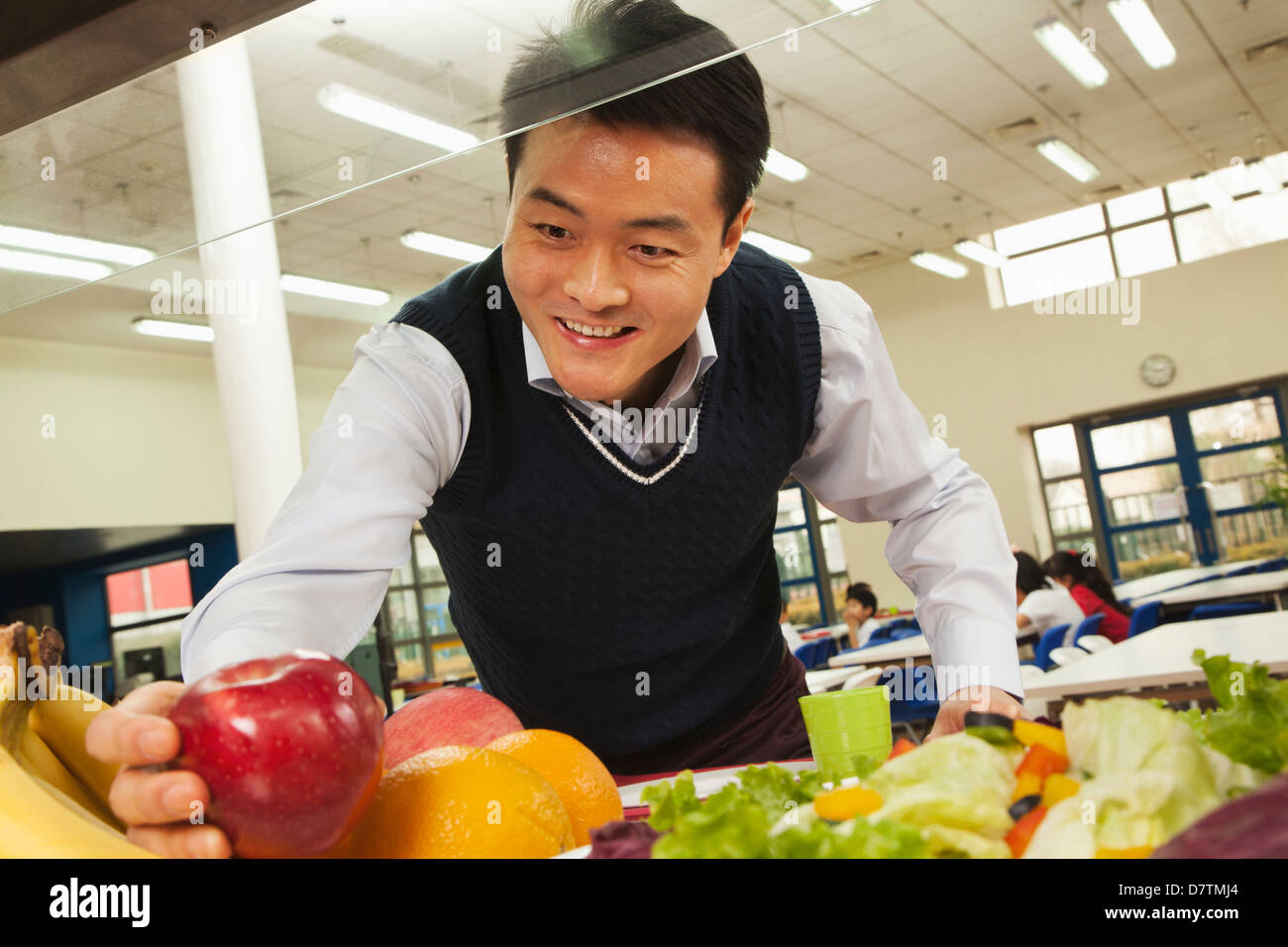 Teacher reaching for healthy food in school cafeteria Stock Photo - Alamy