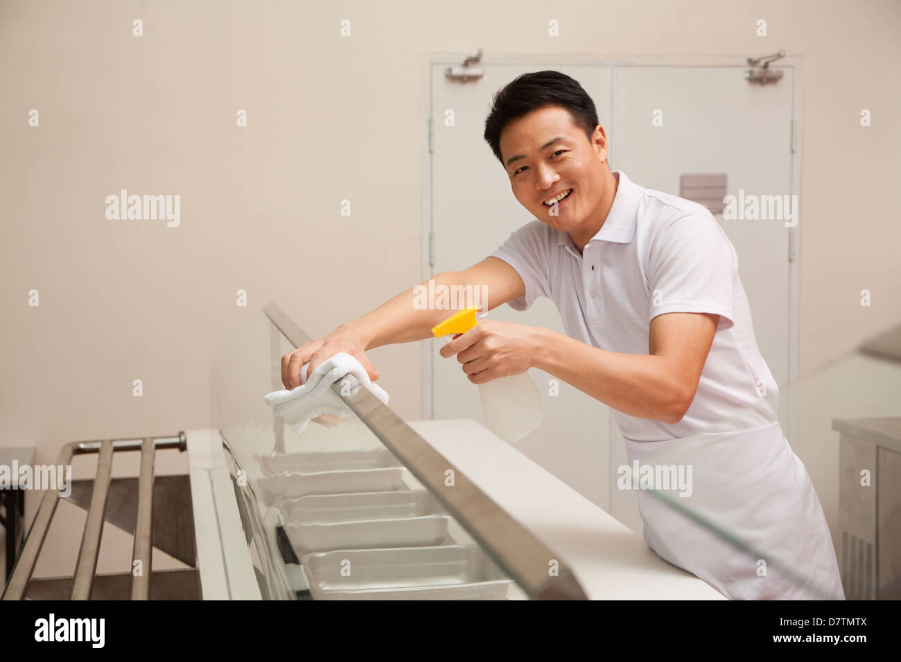 Cafeteria worker cleaning food serving area Stock Photo - Alamy