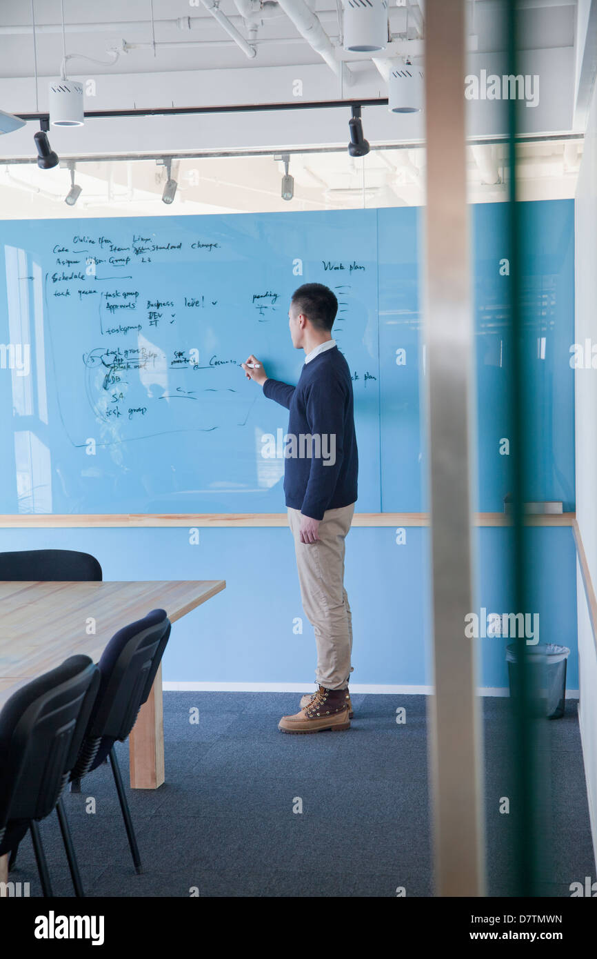 Businessman writing notes on the glass board Stock Photo - Alamy
