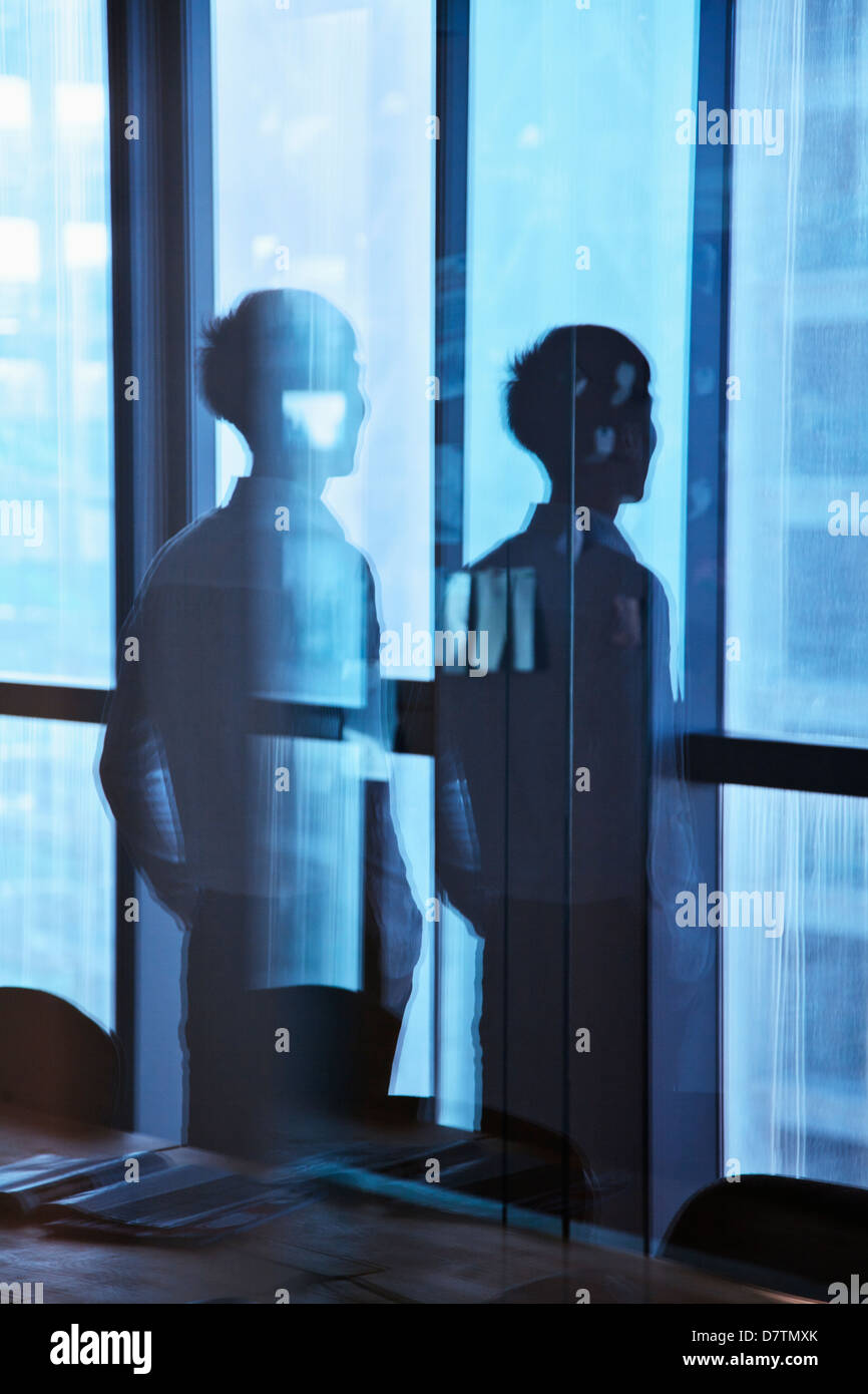 Reflection of businessman looking outside the window Stock Photo - Alamy