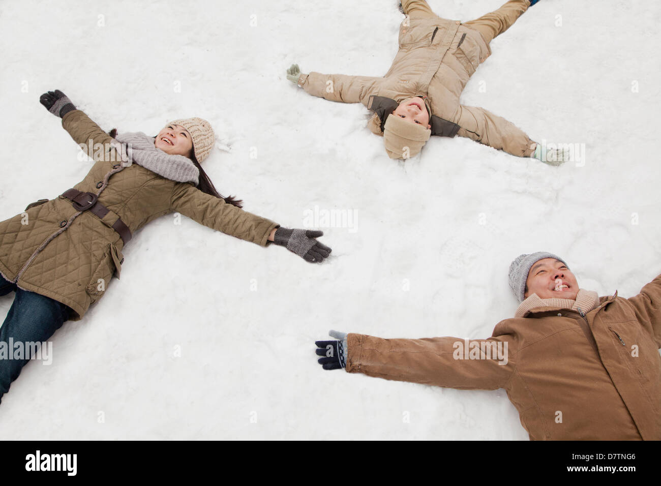 Family laying in snow making snow angels Stock Photo - Alamy