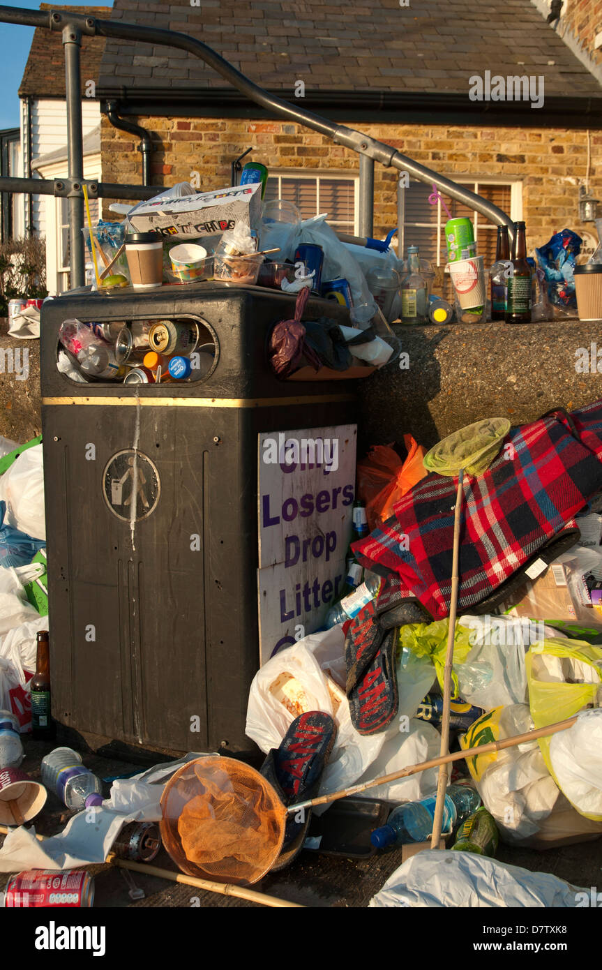 Over filled rubbish bin at the end of a busy day waste paper plastic ...