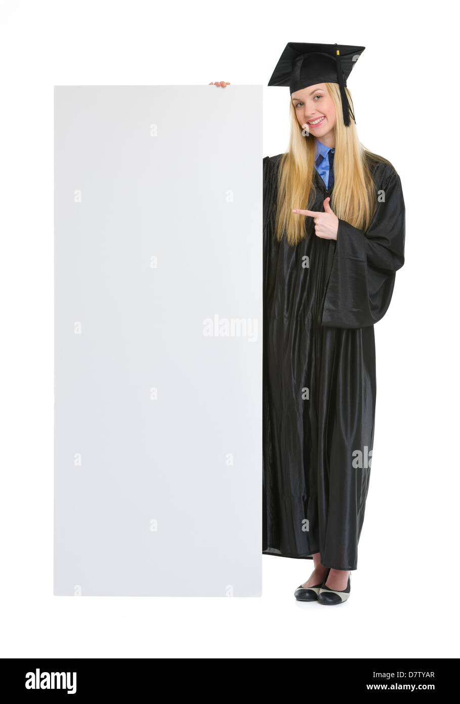 Happy young woman in graduation gown pointing on blank billboard Stock ...