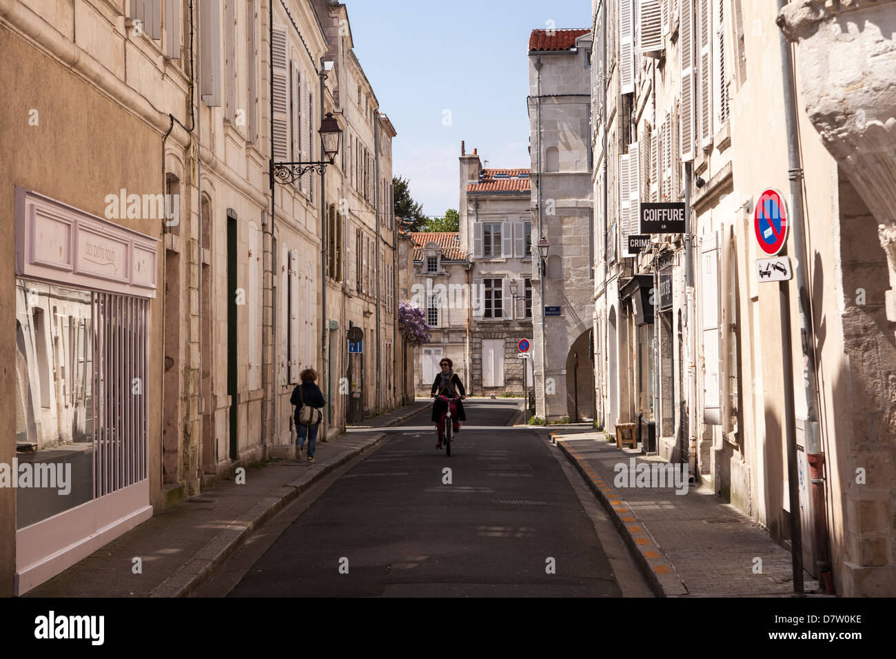 A woman cycles down a side street in the old city of La Rochelle ...