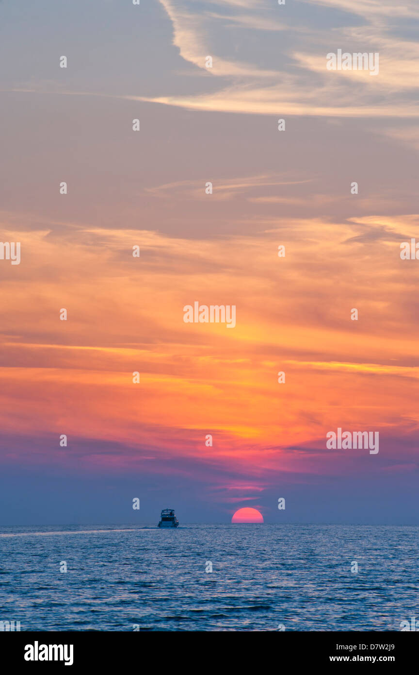 Boat driving into the sunset at Zlatni Rat Beach, Bol, Brac Island ...