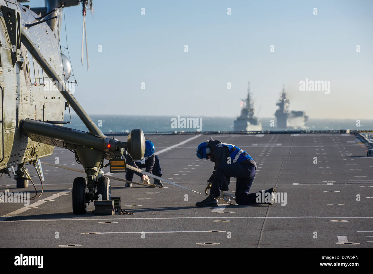Aircraft handler on deck of HMS Bulwark readying a Sea King Mk4 for ...