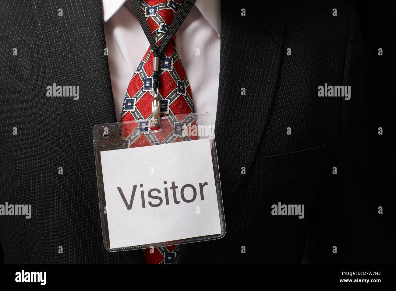 businessman wearing a visitor identification badge around his neck ...