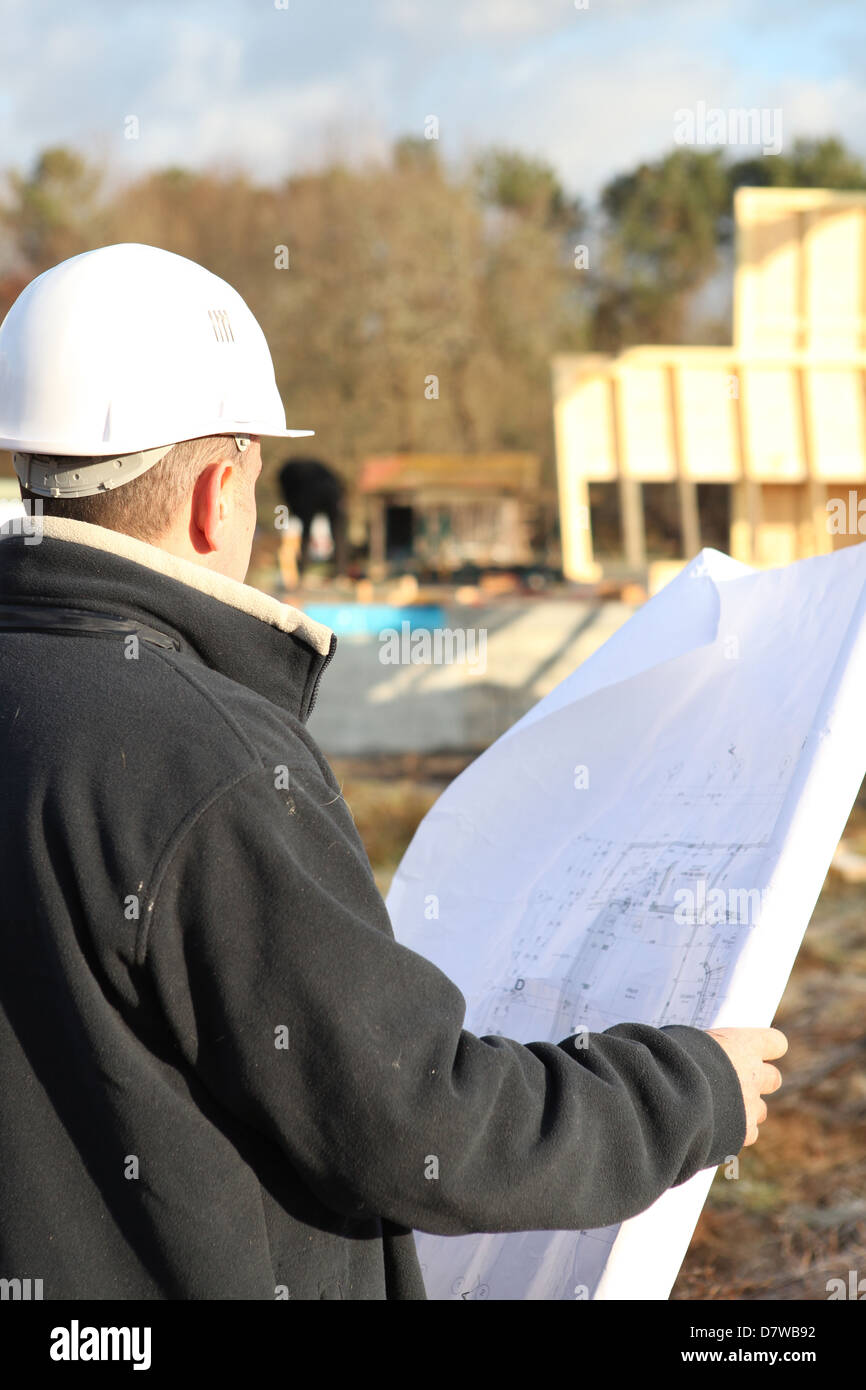 Builder on site with plans Stock Photo - Alamy