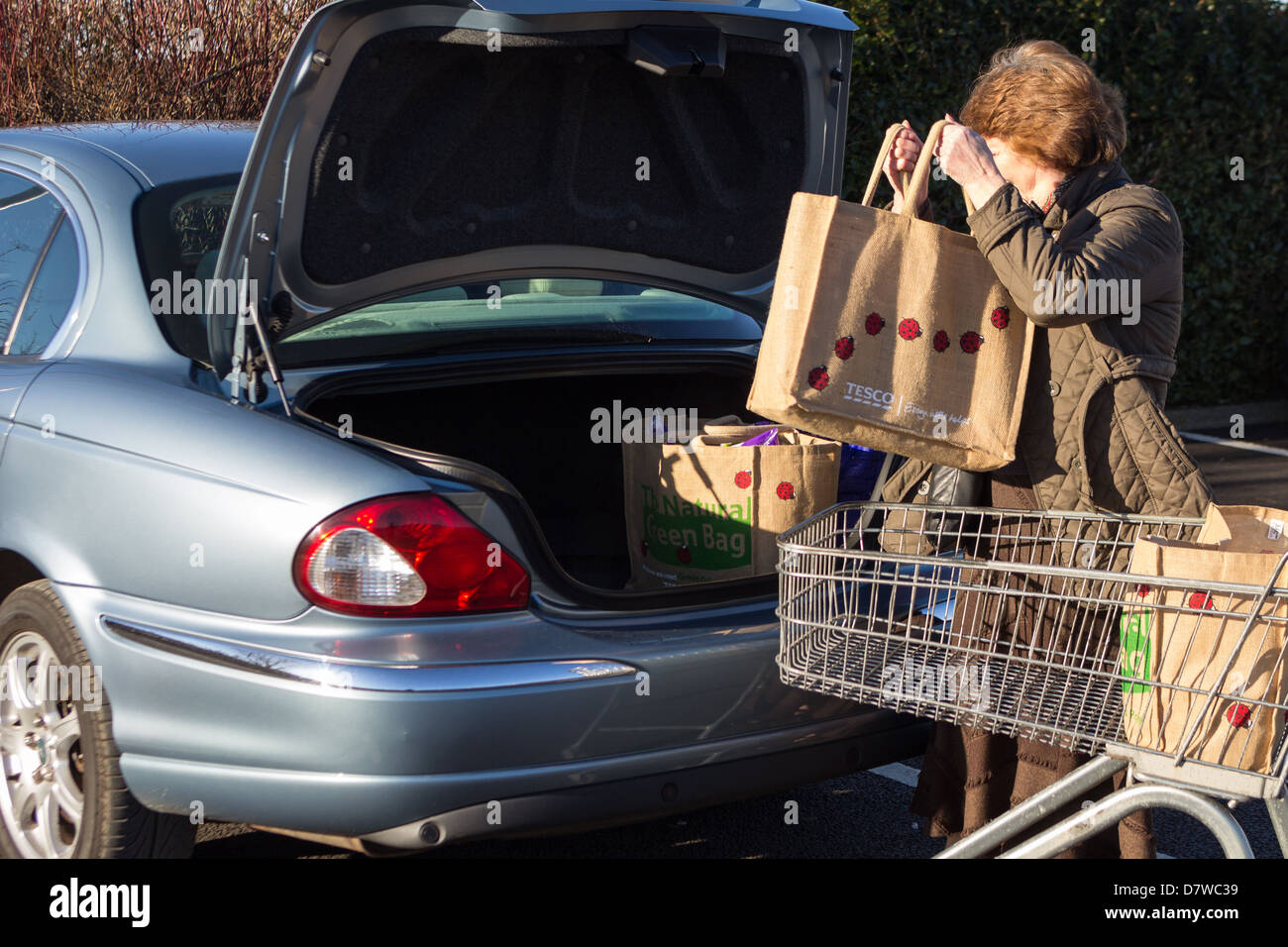 day in the life, woman loading shopping into car with re use bags ...