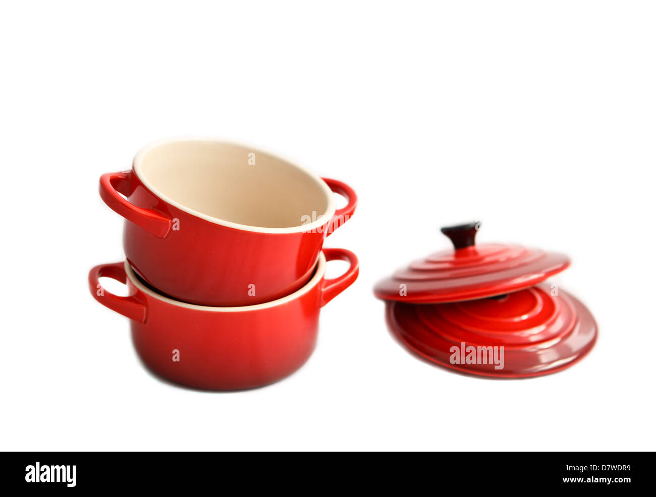 Two red cocottes (small casserole) with covers on a white background ...