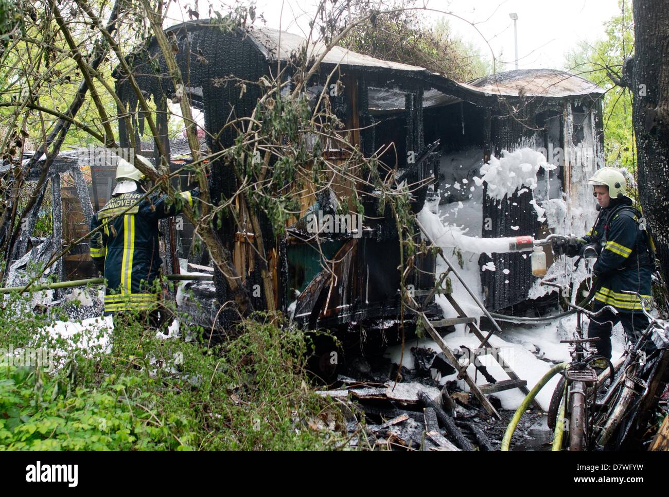 Firemen extinguish the fire in a burning caravan in Hanover, Germany ...