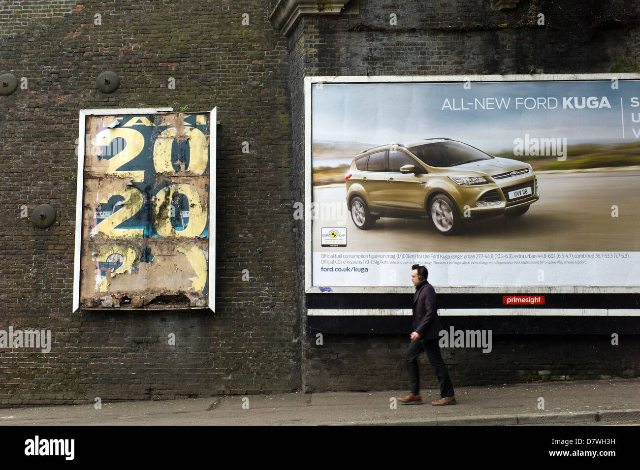 Man walking past posters, Brighton, UK Stock Photo - Alamy
