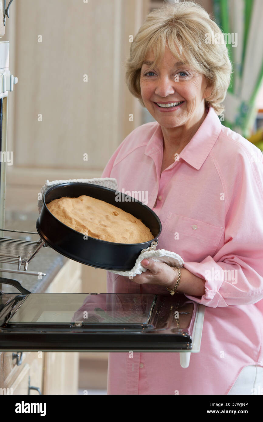 Elderly woman baking a cake Stock Photo - Alamy