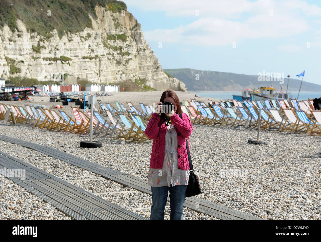 Female photographer taking a picture on the beach Beer Devon England uk ...