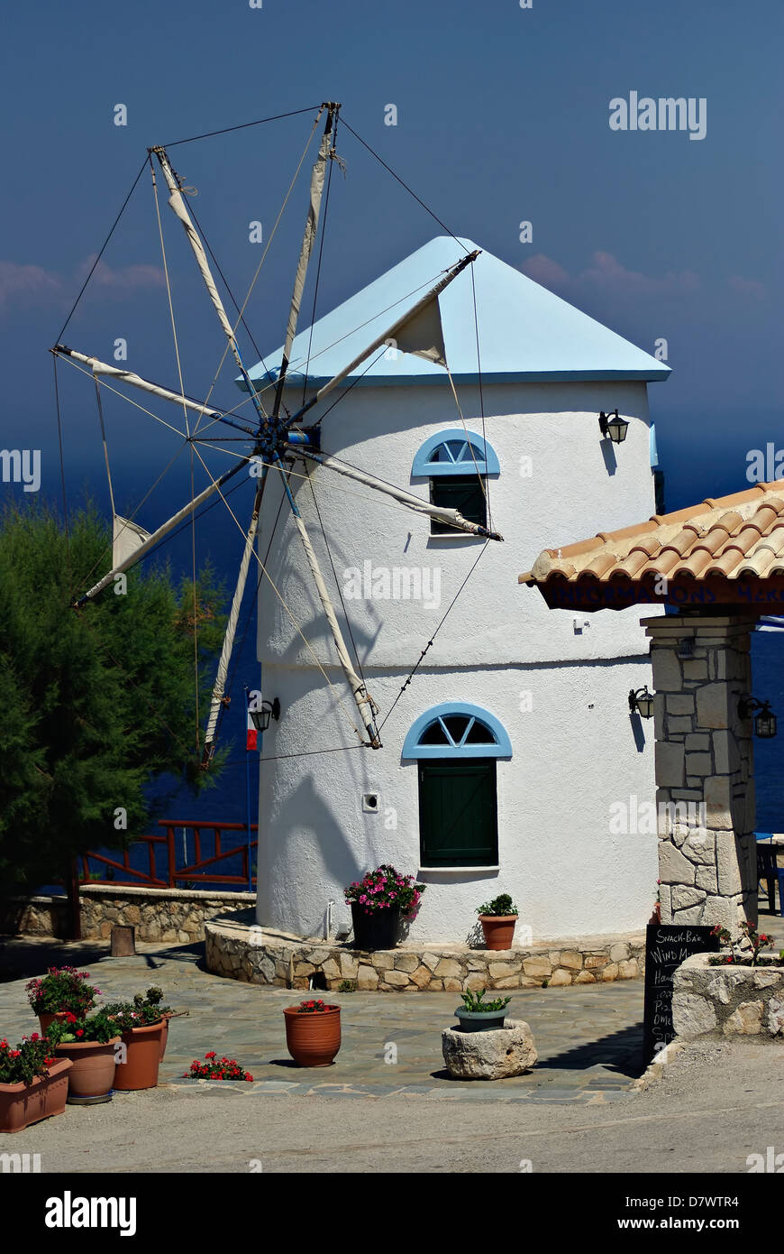 Traditional Greek windmill painted white with light blue roof at sunny ...