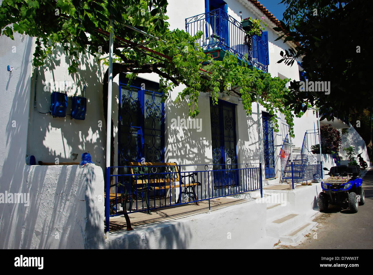 Traditional greek house painted in white with blue details at sunny ...