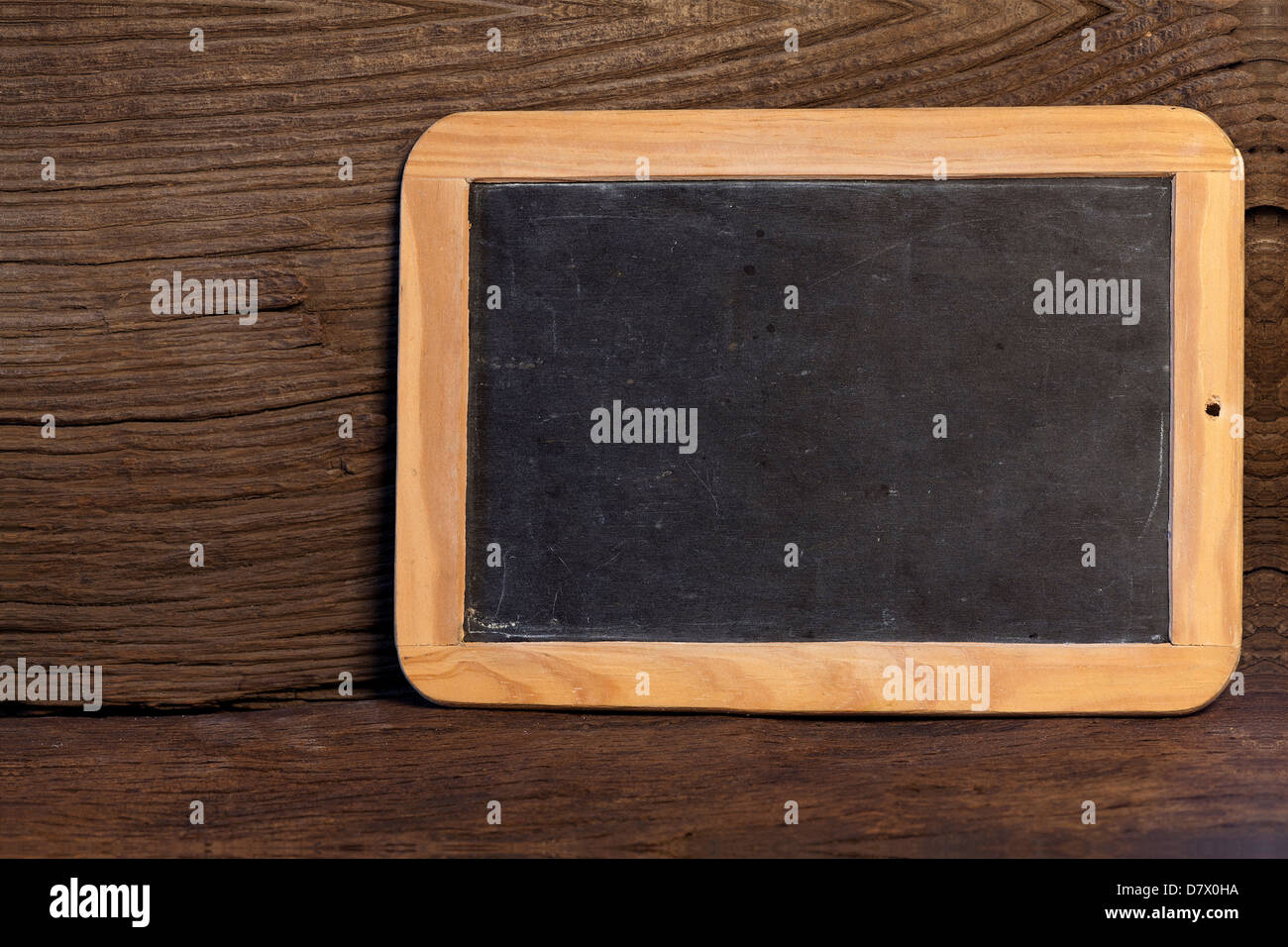 Old slate blackboard to describe on a dark rustic wooden background ...