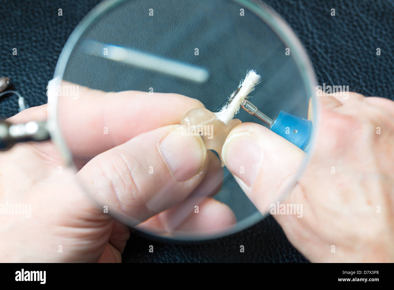 hearing aid acoustician at work, he is working on a hearing aid for ...