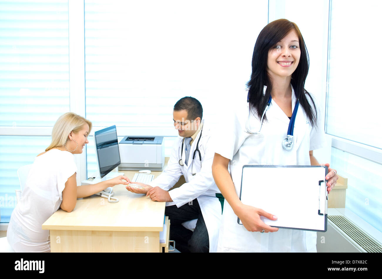 Young nurse, behind the doctor advises the patient Stock Photo - Alamy
