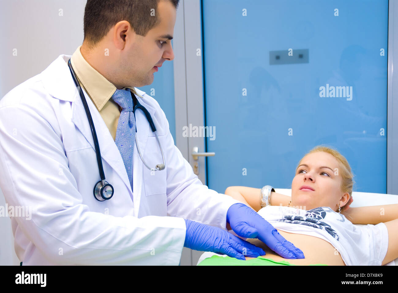 The doctor examines the patient's abdomen.Doctor and patient shoot a ...