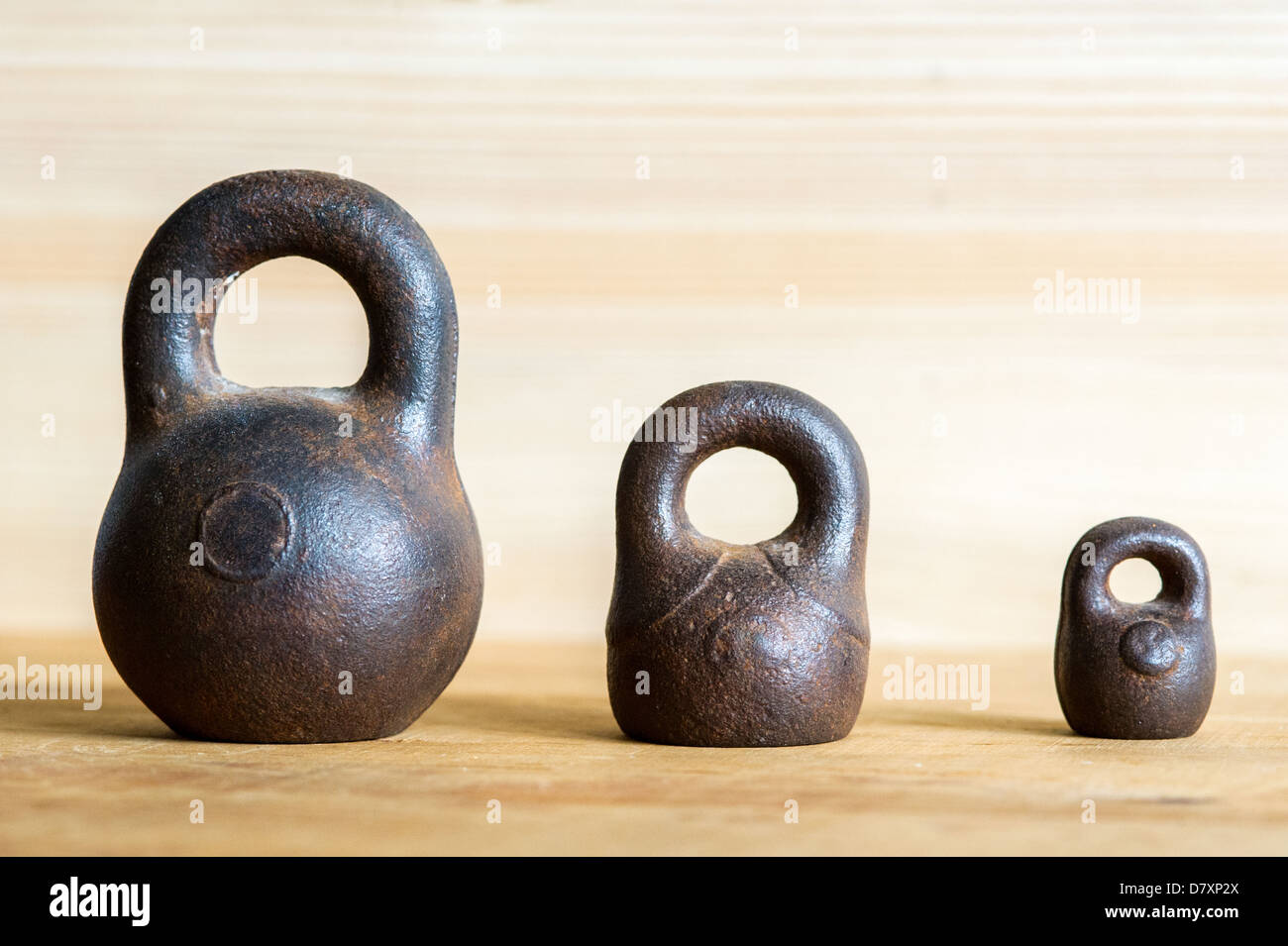 Three small calibration weights standing on wooden background Stock ...
